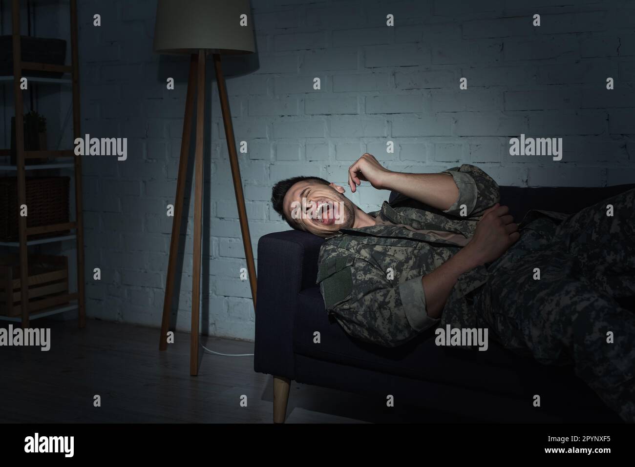 Stressed military man screaming while suffering from post traumatic ...