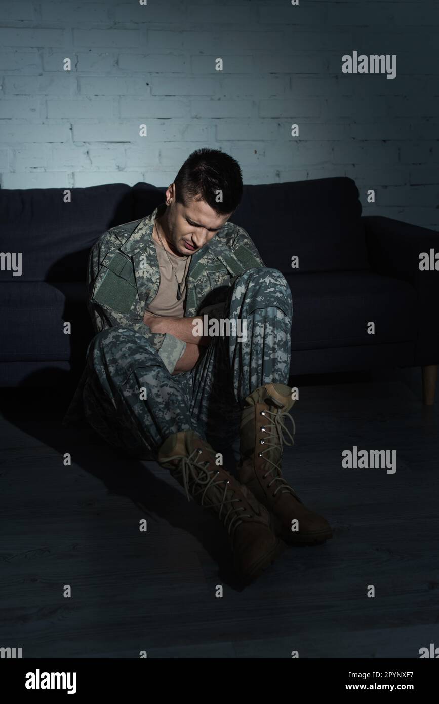 depressed serviceman in military uniform suffering from post traumatic ...