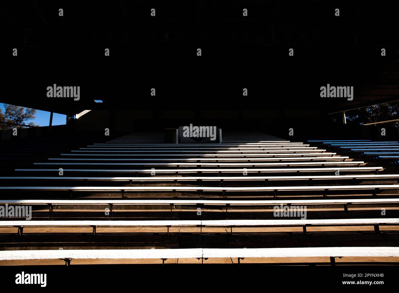An empty sports stadium featuring a set of bleachers with an exit sign ...