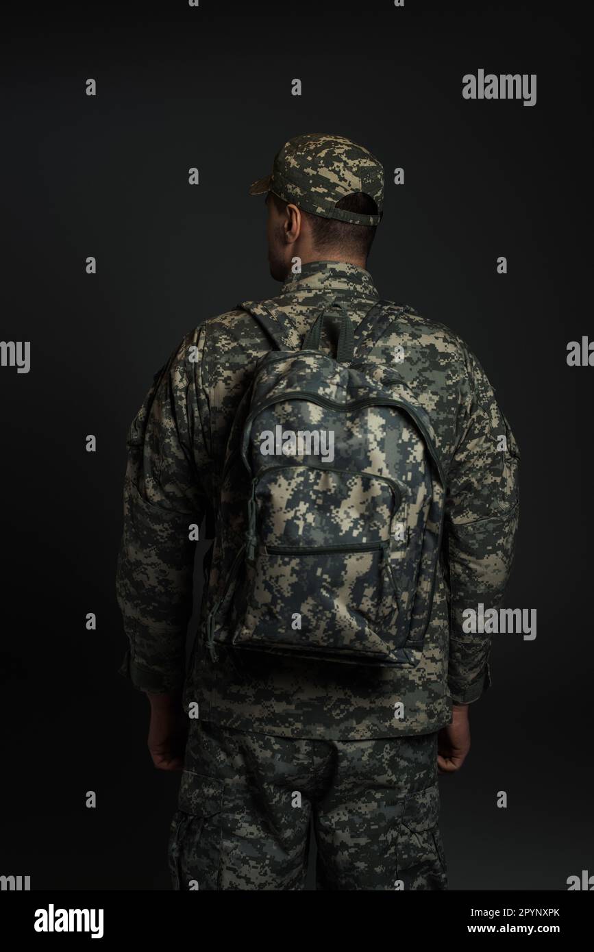 back view of patriotic soldier in camouflage uniform standing with ...