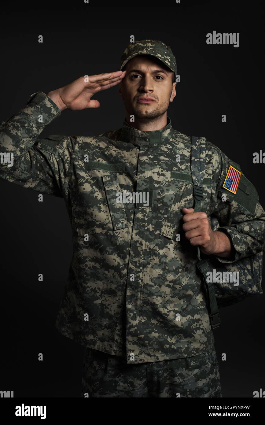 patriotic soldier in uniform with American flag saluting isolated on ...