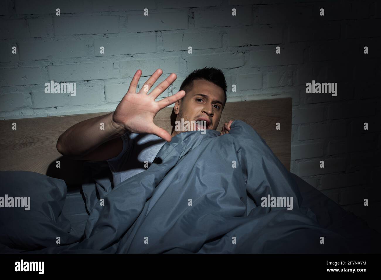 scared man with panic attacks screaming while lying under blanket,stock ...