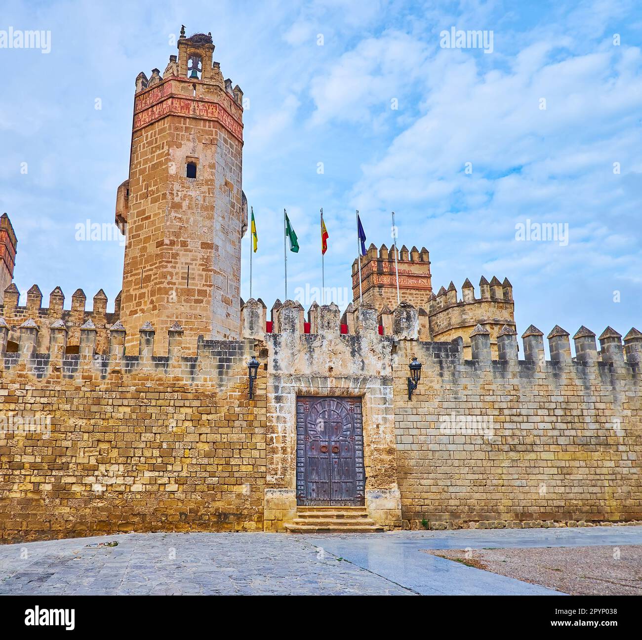 The medieval gate with carved wooden doors, battlements and tall ...