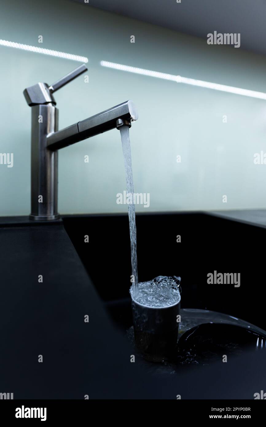 Kitchen sink with dishes and water running Stock Photo - Alamy