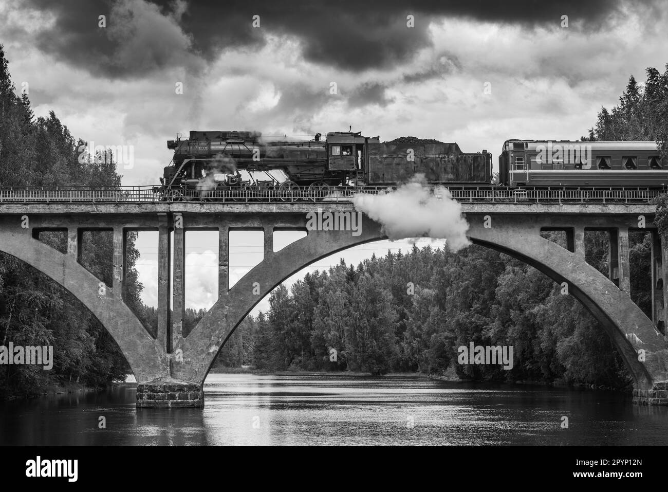 Retro steam train moves above the river Stock Photo - Alamy