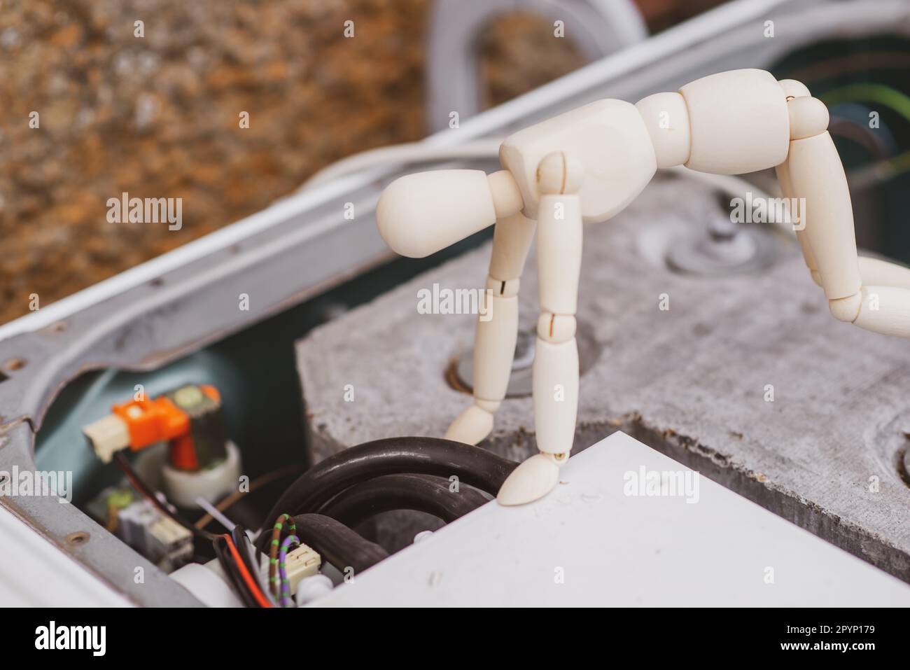 washing machine repair concept. A human figurine looks at the ...