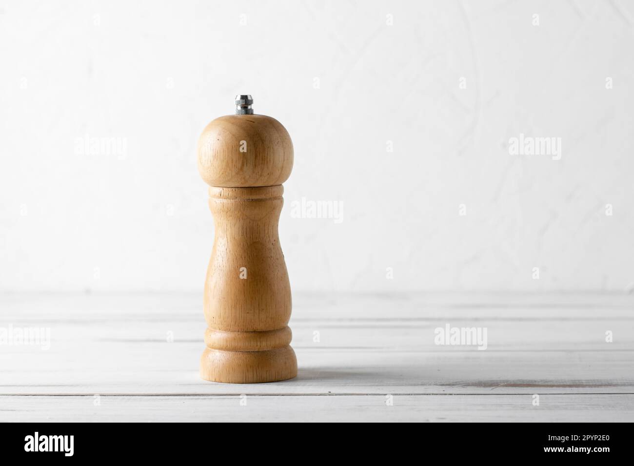 Wooden pepper shaker grinder on a white wooden background Stock Photo ...