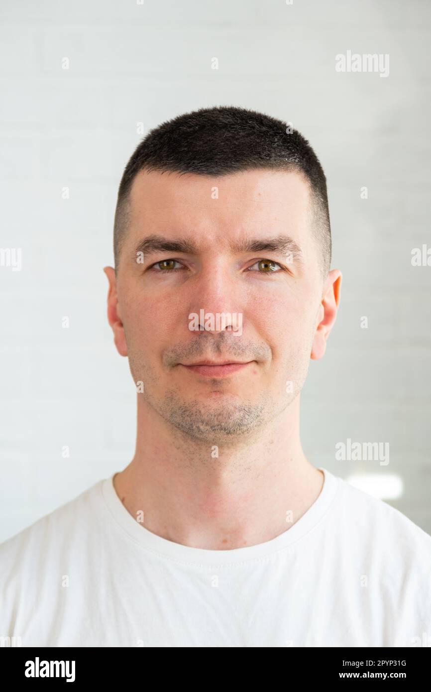 Portrait of a man in close-up on a white background in a white T-shirt ...