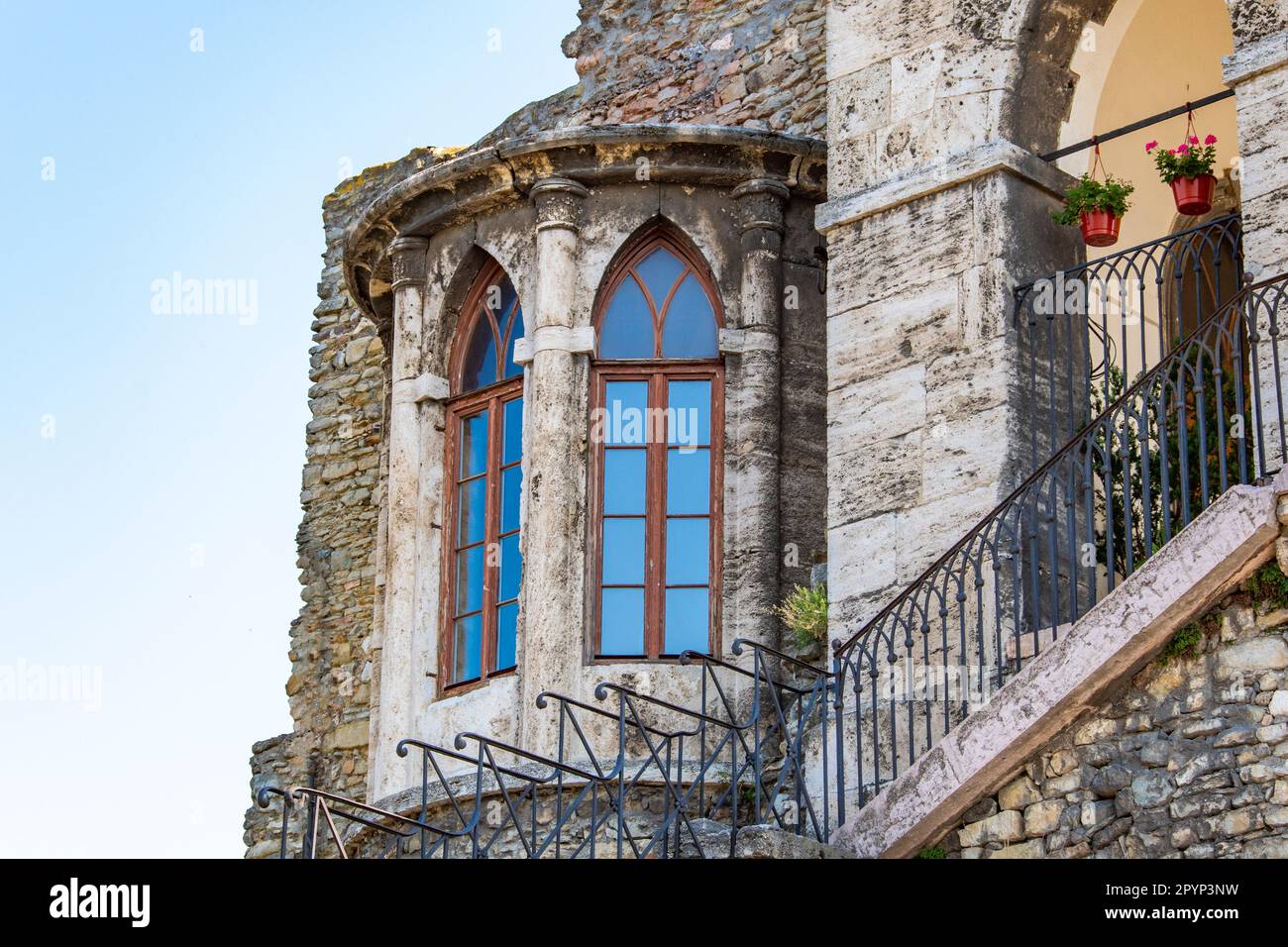 Old medieval castle with long windows and a staircase surrounded by ...