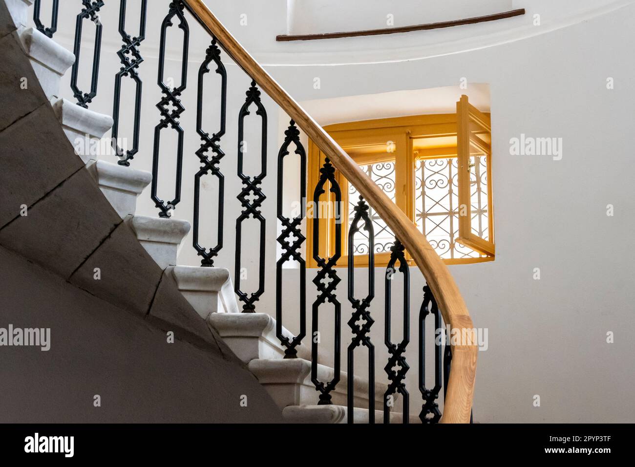 Ornate staircase with wrought iron railing and wooden window Stock ...
