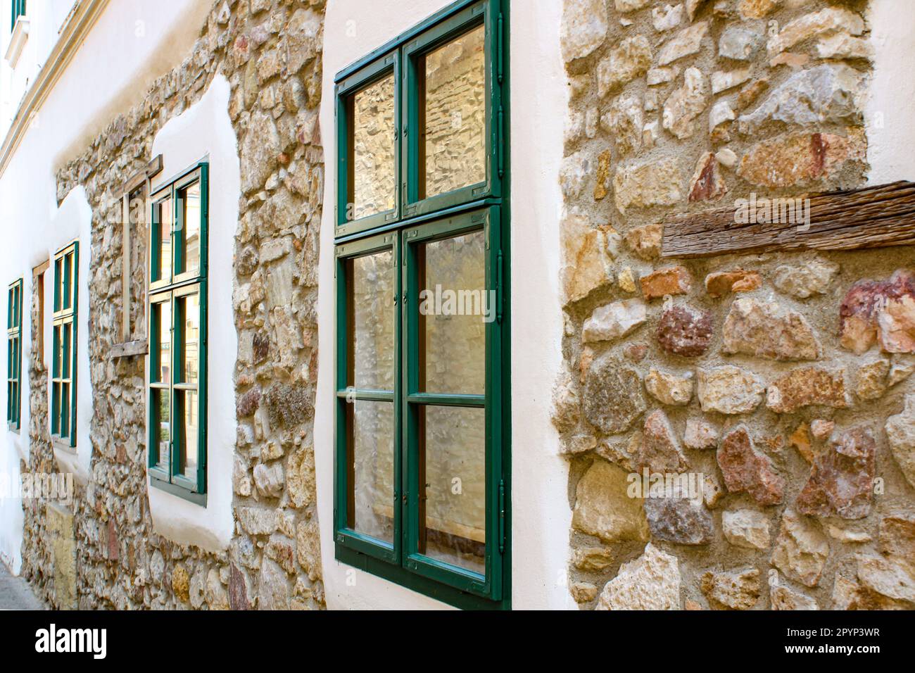 Medieval house wall made of stone with green framed windows Stock Photo ...