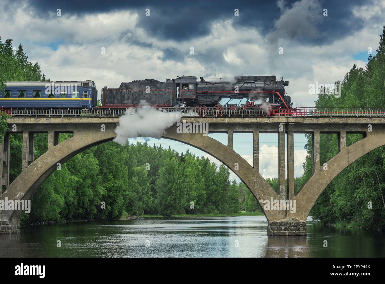 Retro steam train moves above the river Stock Photo - Alamy