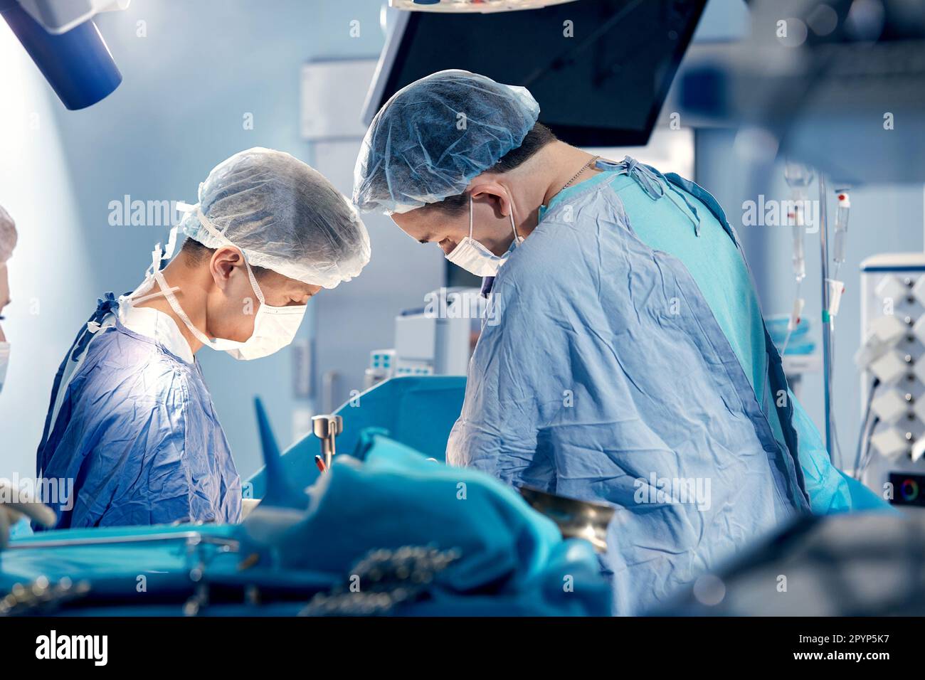 The team of surgeons in the operating room bent over the patient ...