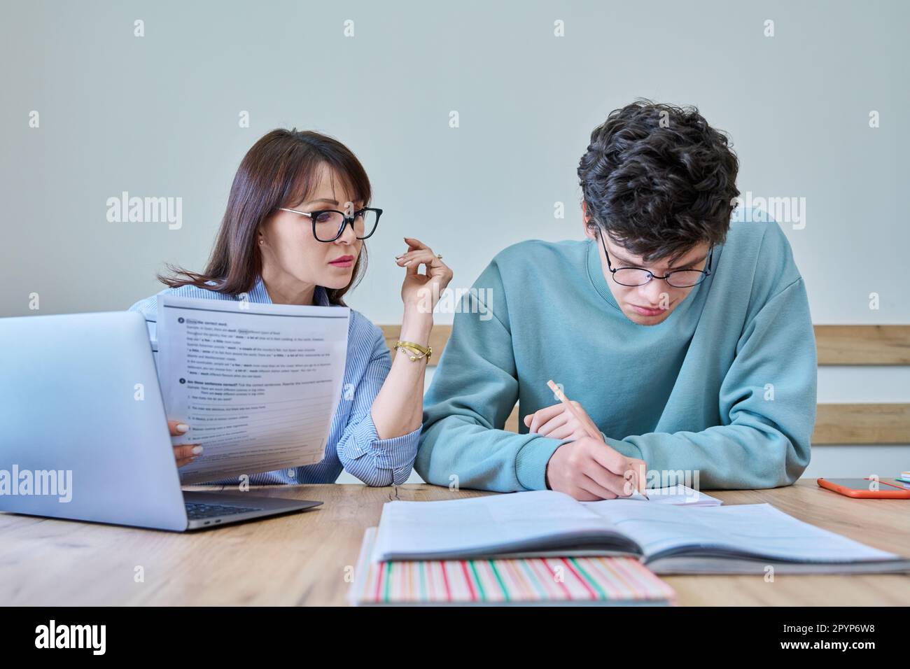 Young teenage male studying languages with teacher in classroom Stock ...