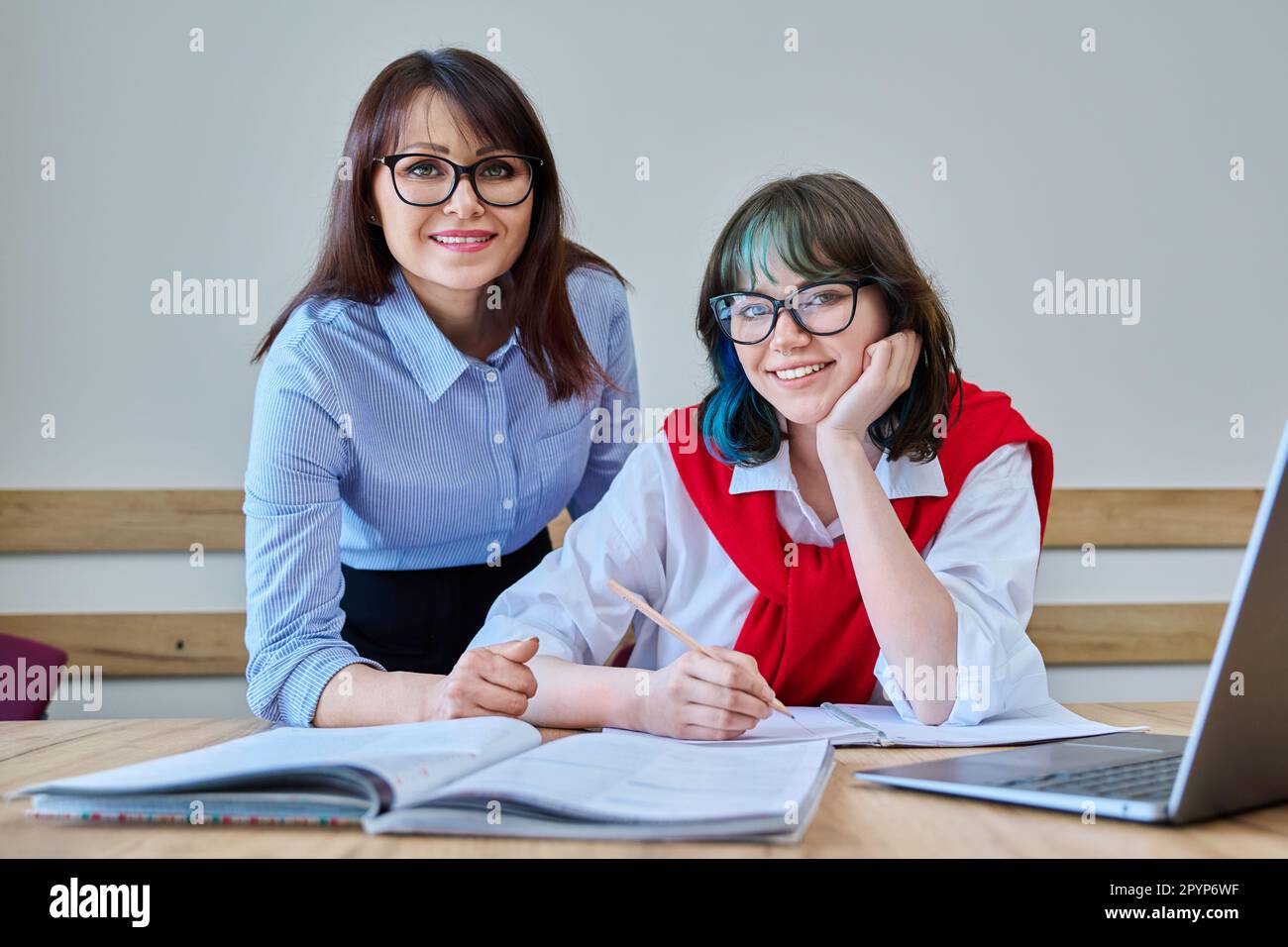 College student girl sitting with female teacher studying individually ...