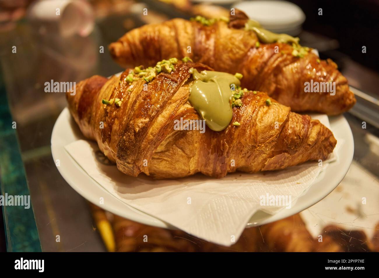 Assortment of freshly baked croissants for sale on counter of shop ...