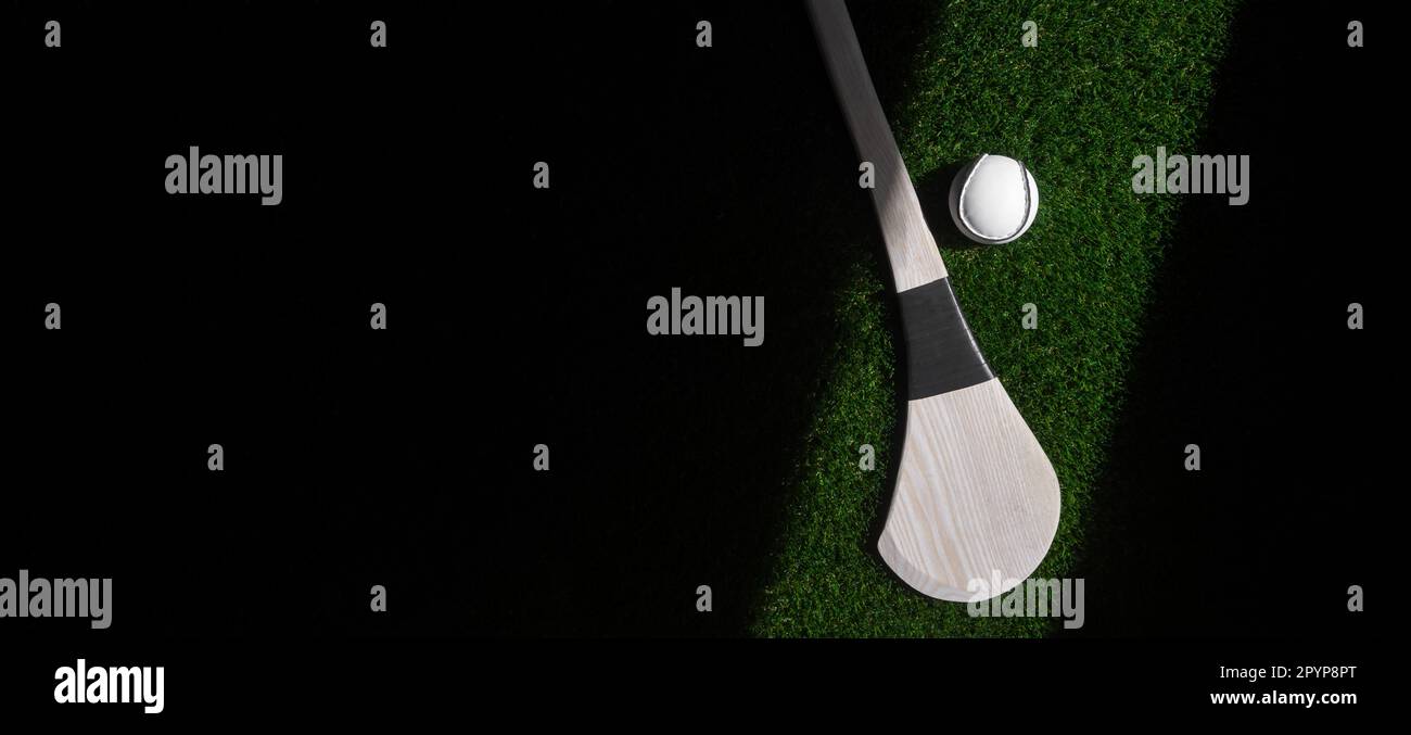 Hurling bat and sloitar on green grass. Horizontal sport theme poster ...