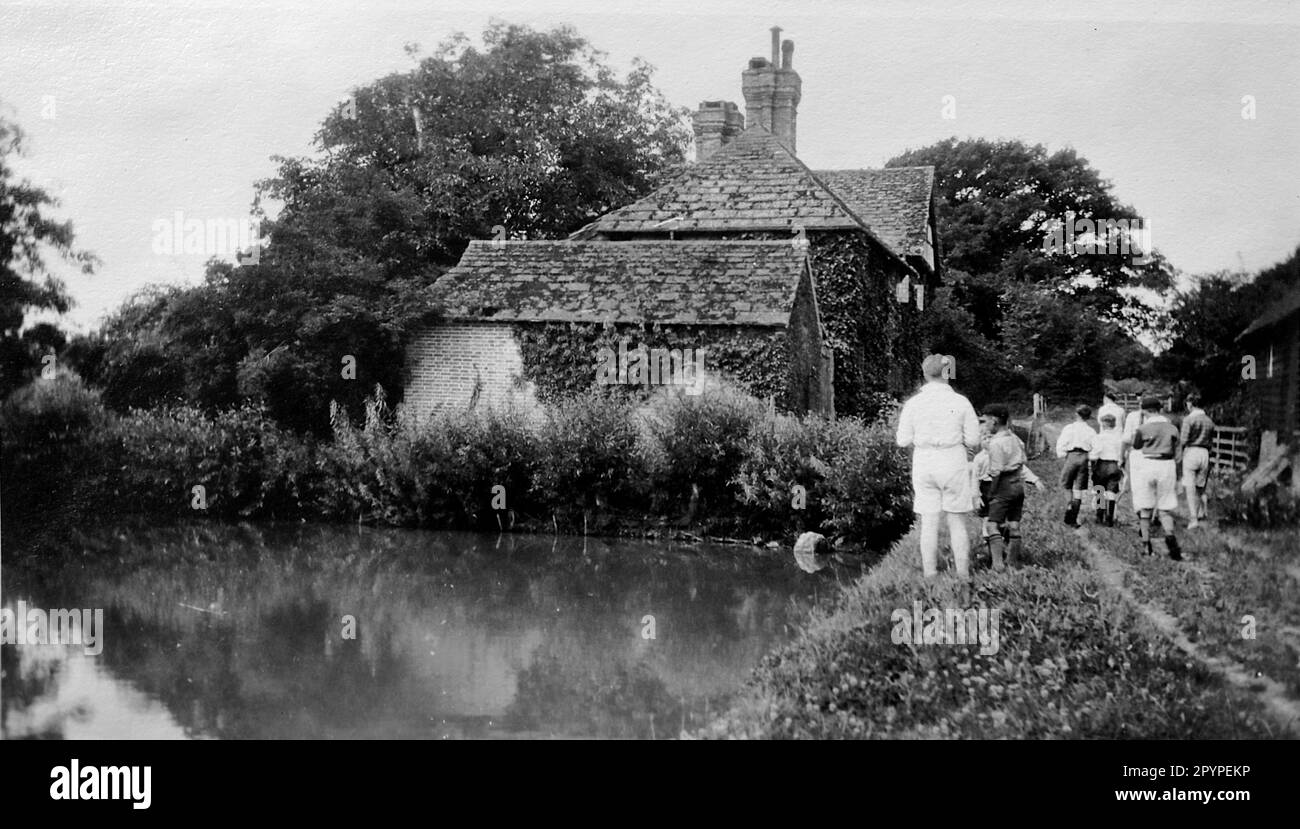 Boys and young men beside a lake and country cottage, c1928. From a ...