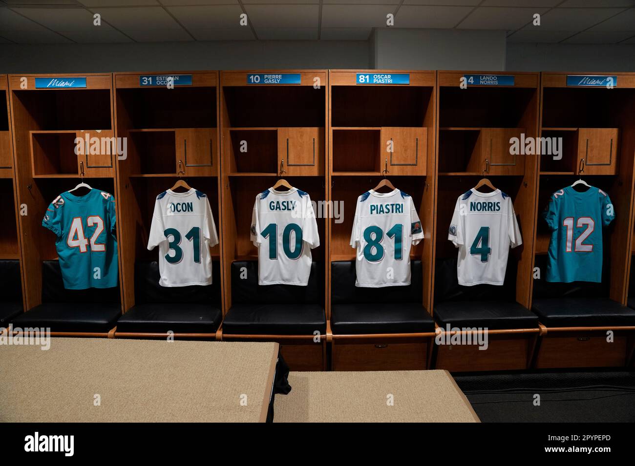 Jerseys with the names of Formula One drivers hang in a press ...