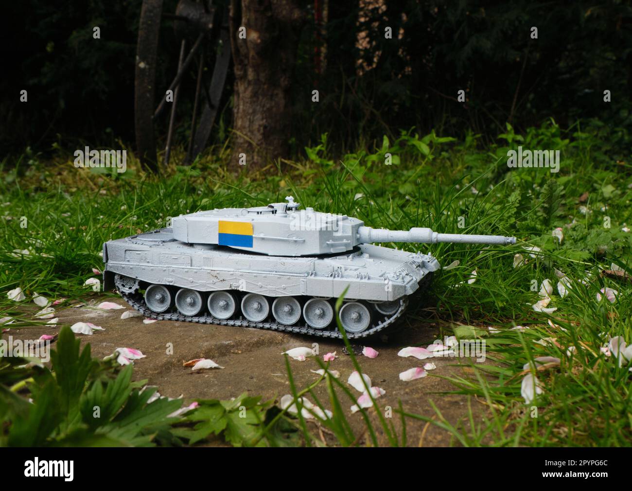 A German Leopard 2 tank in winter camouflage and a Ukraine flag on its ...