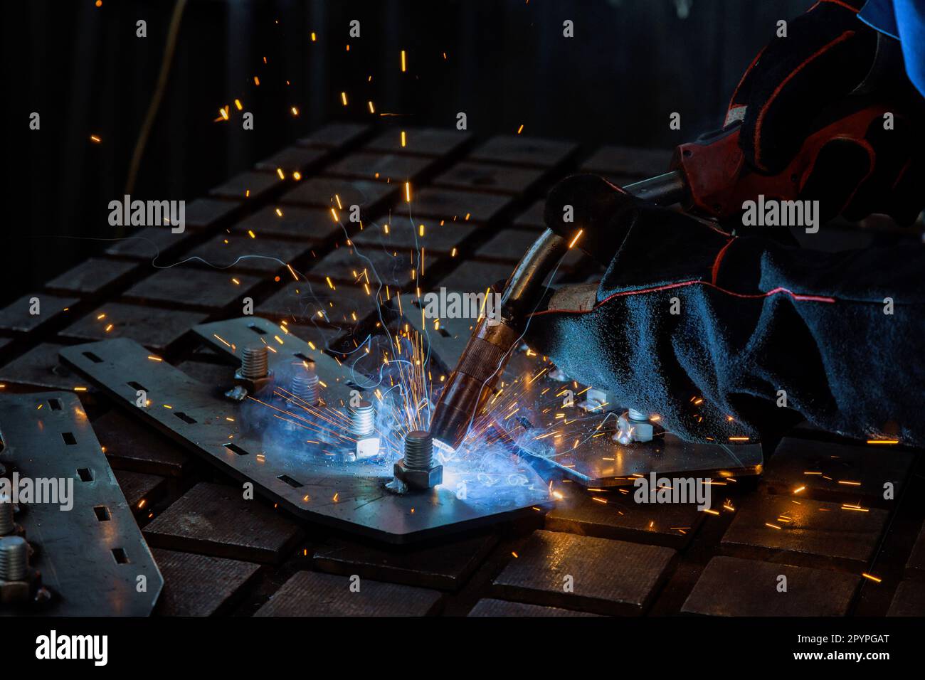 There is workplace where worker is welding steel at work there is a ...