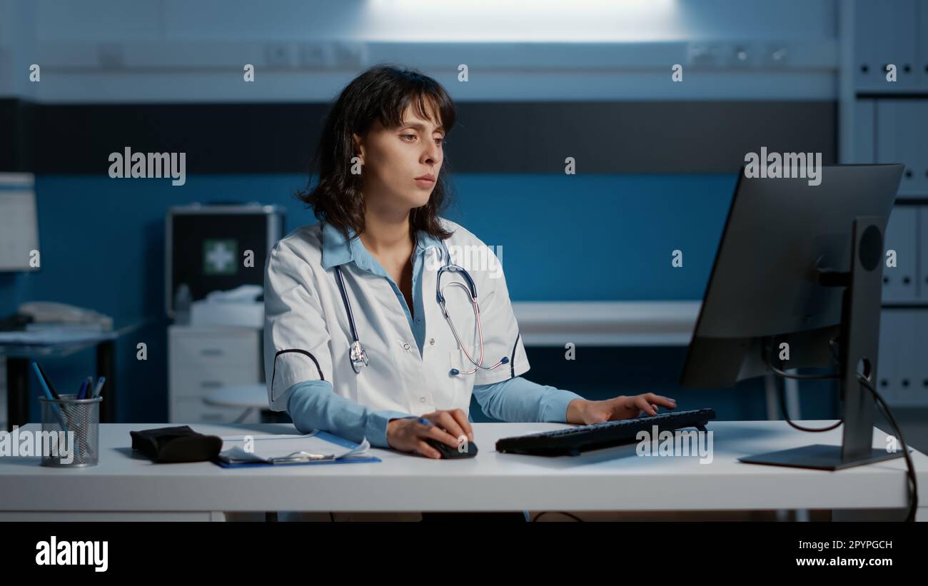 Specialist doctor standing at desk in hospital office working over ...