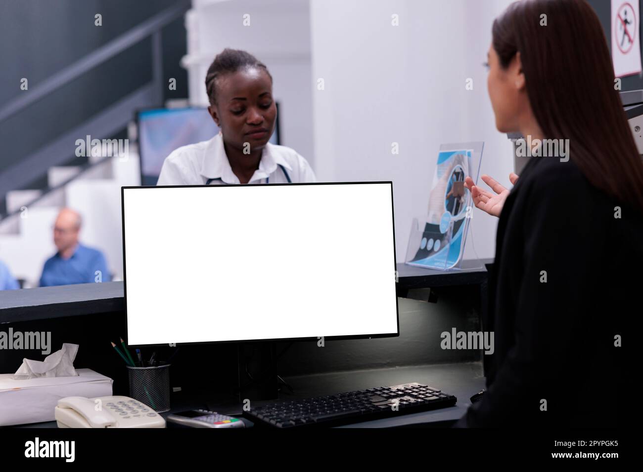 Asian receptionist using white screen on computer while working at ...