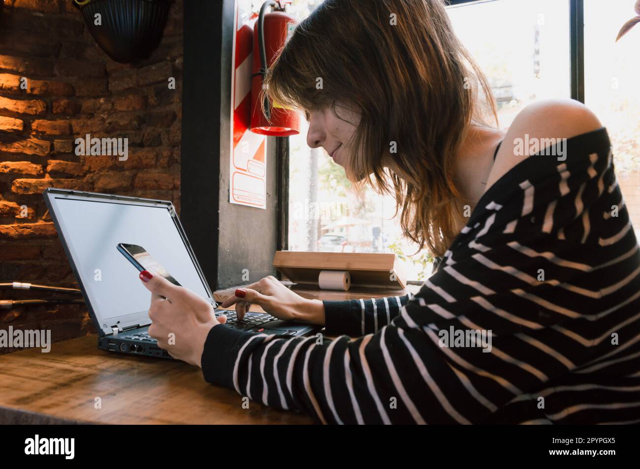 freelance young transgender latina woman in restaurant sitting working ...