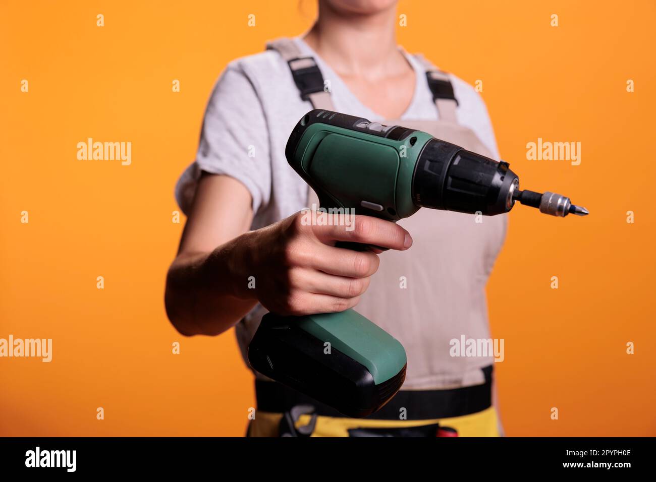 Construction worker holding cordless drilling gun over background ...