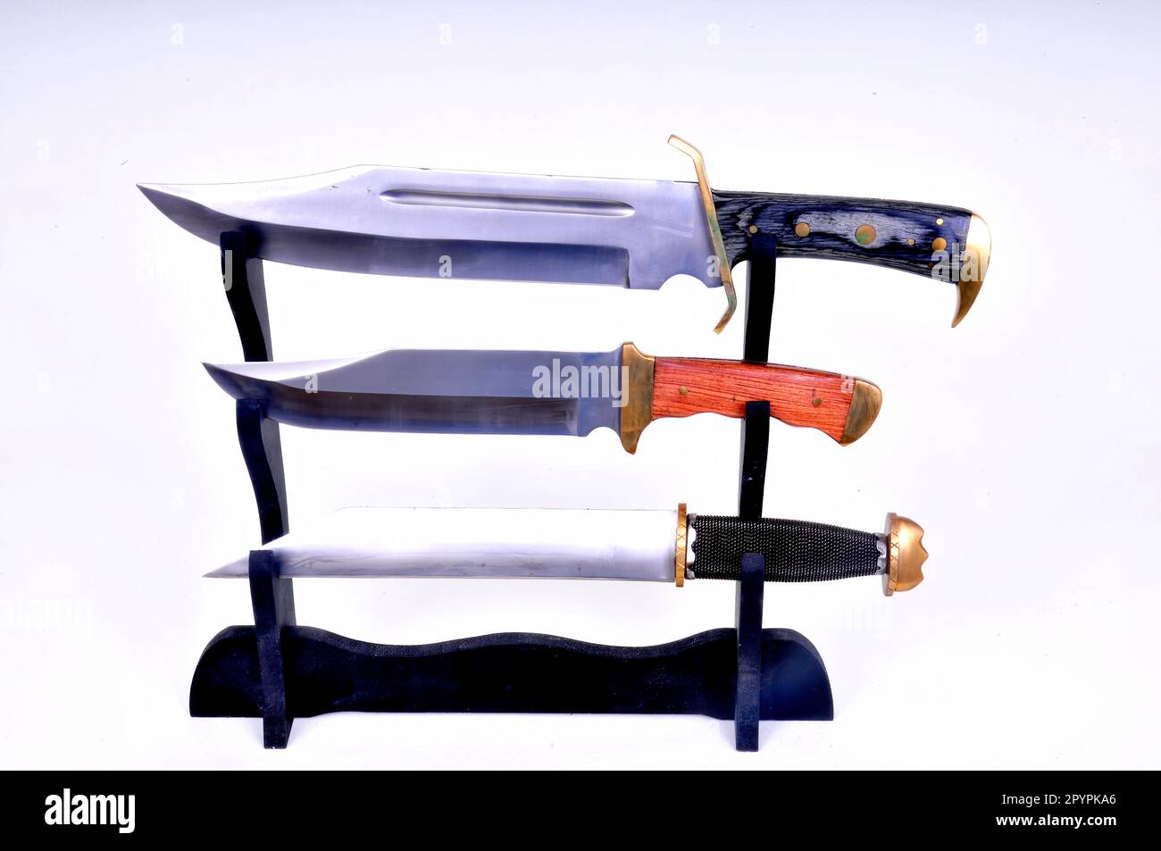 Very large bowie knife and seax isolated over white in display rack ...