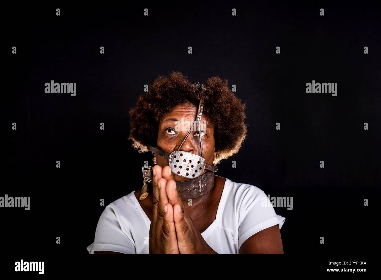 Black woman in chains with an iron mask on her face, representing the ...