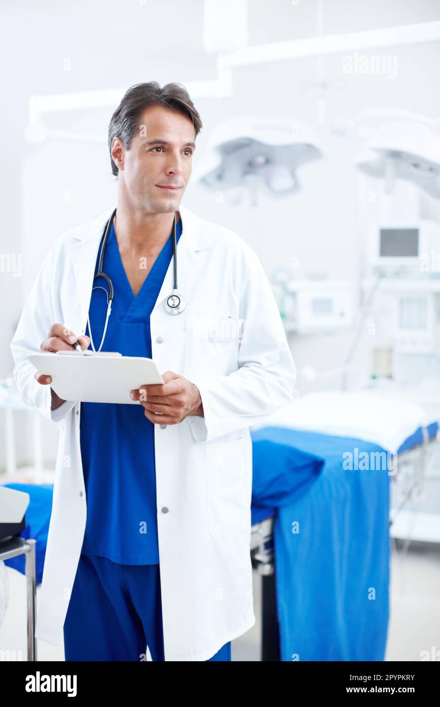 Thinking of the best options. A confident male doctor marking a chart ...