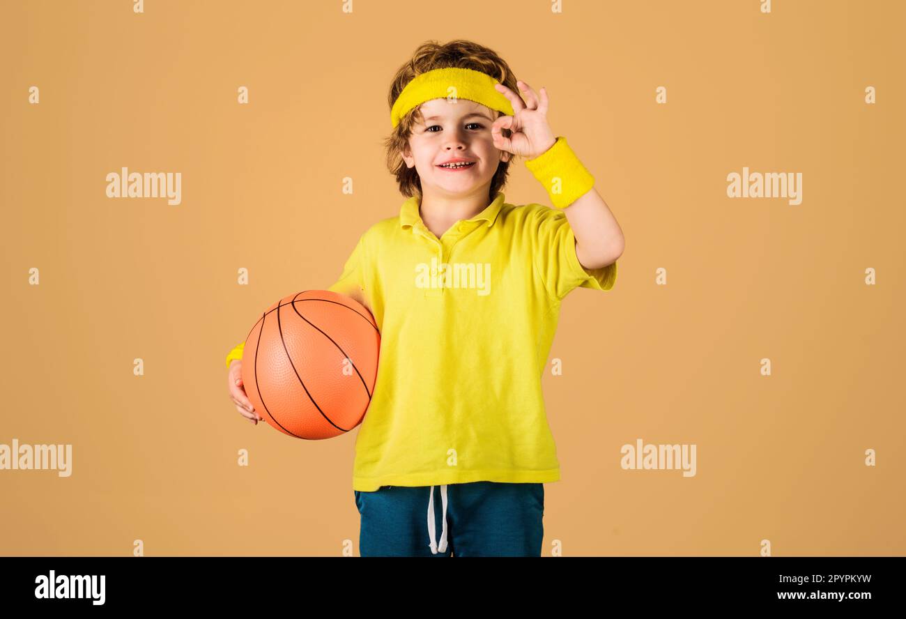 Little basketballer. Smiling child with basketball ball showing sign ok ...