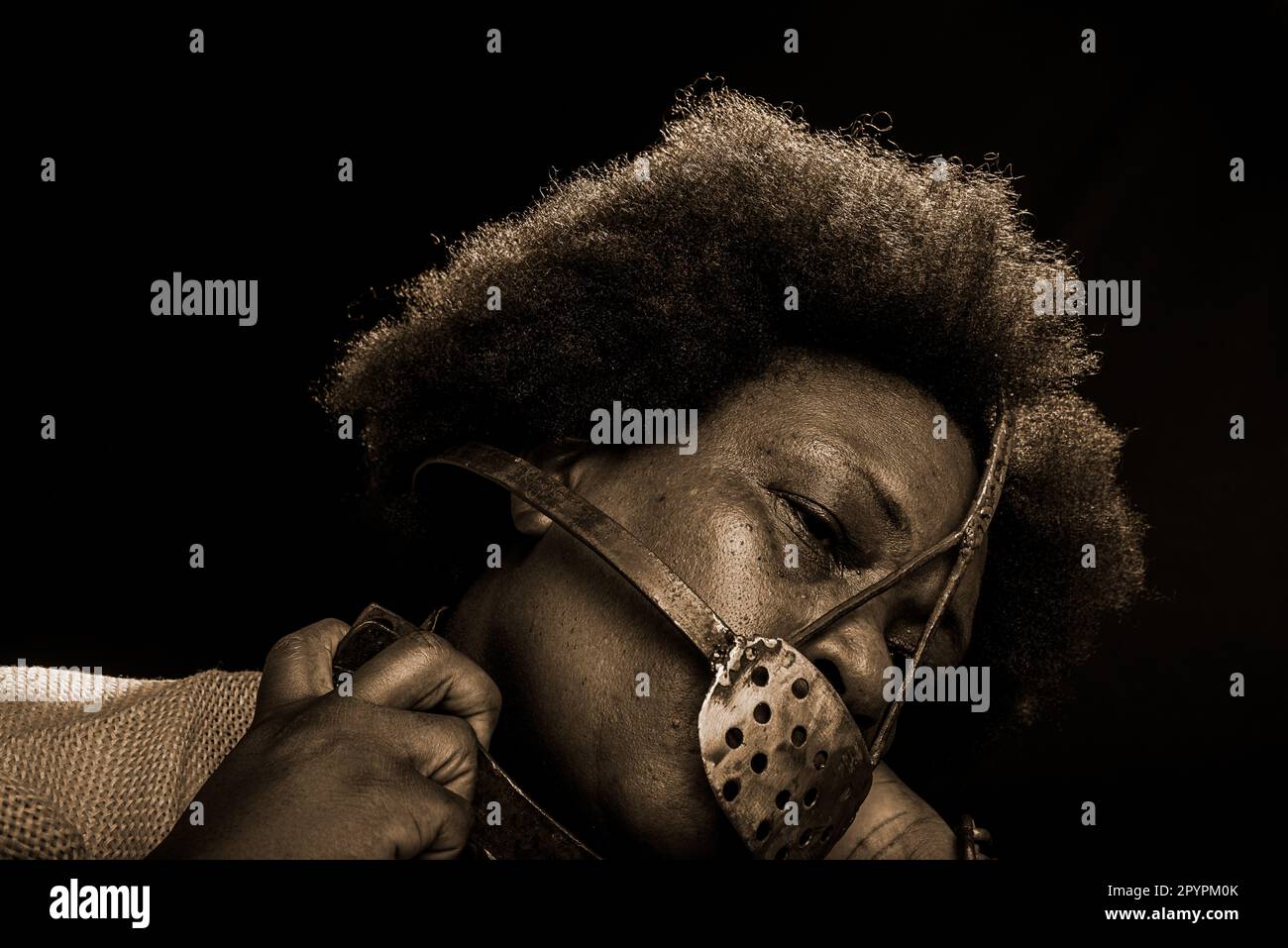 Face portrait of a black woman imprisoned with an iron mask on her face ...
