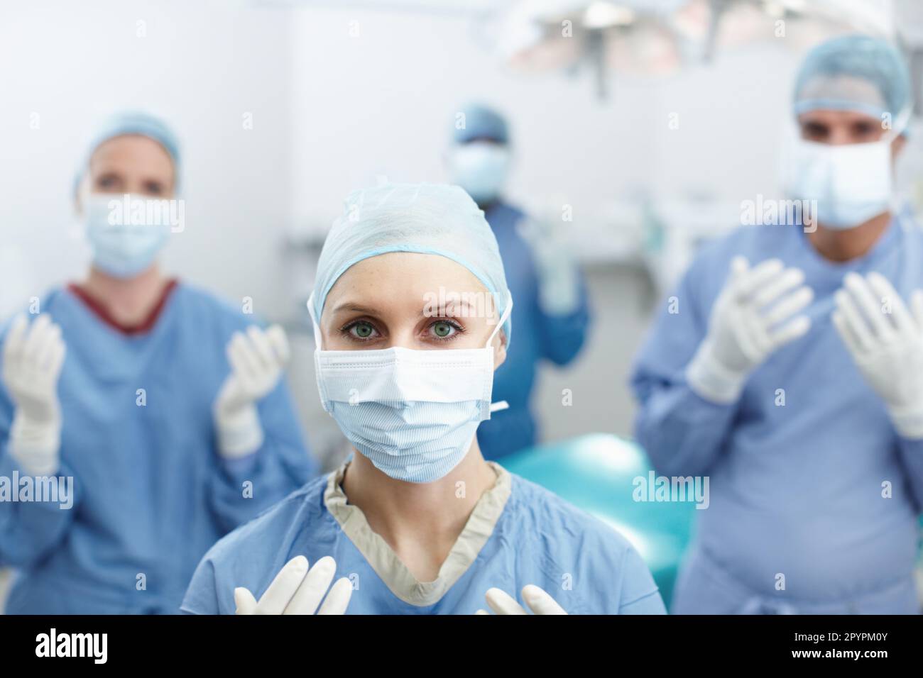 Our work is of the utmost importance. Portrait of four surgeons holding ...