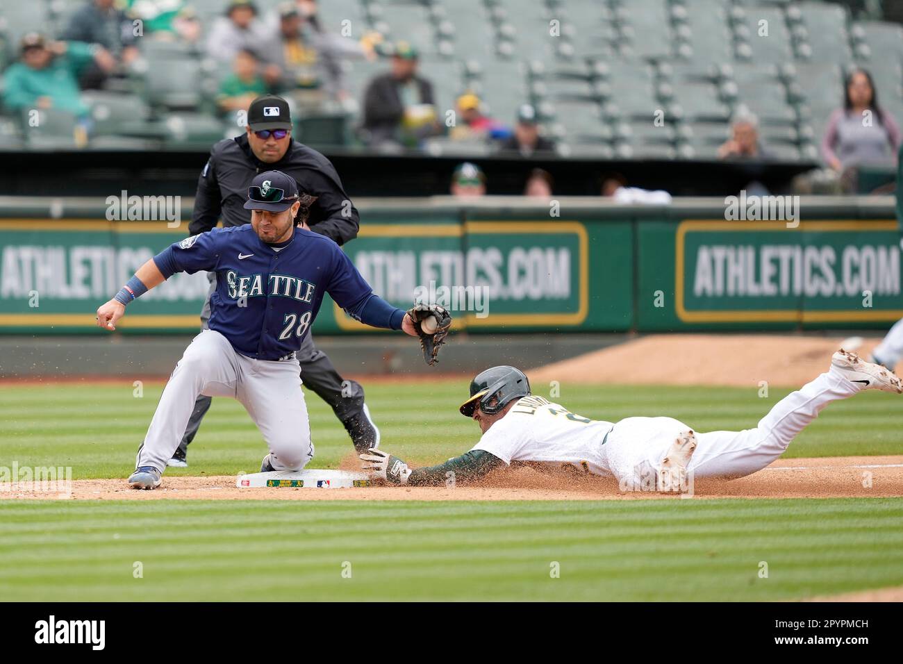 Oakland Athletics' Ramon Laureano, right, slides into third base as ...