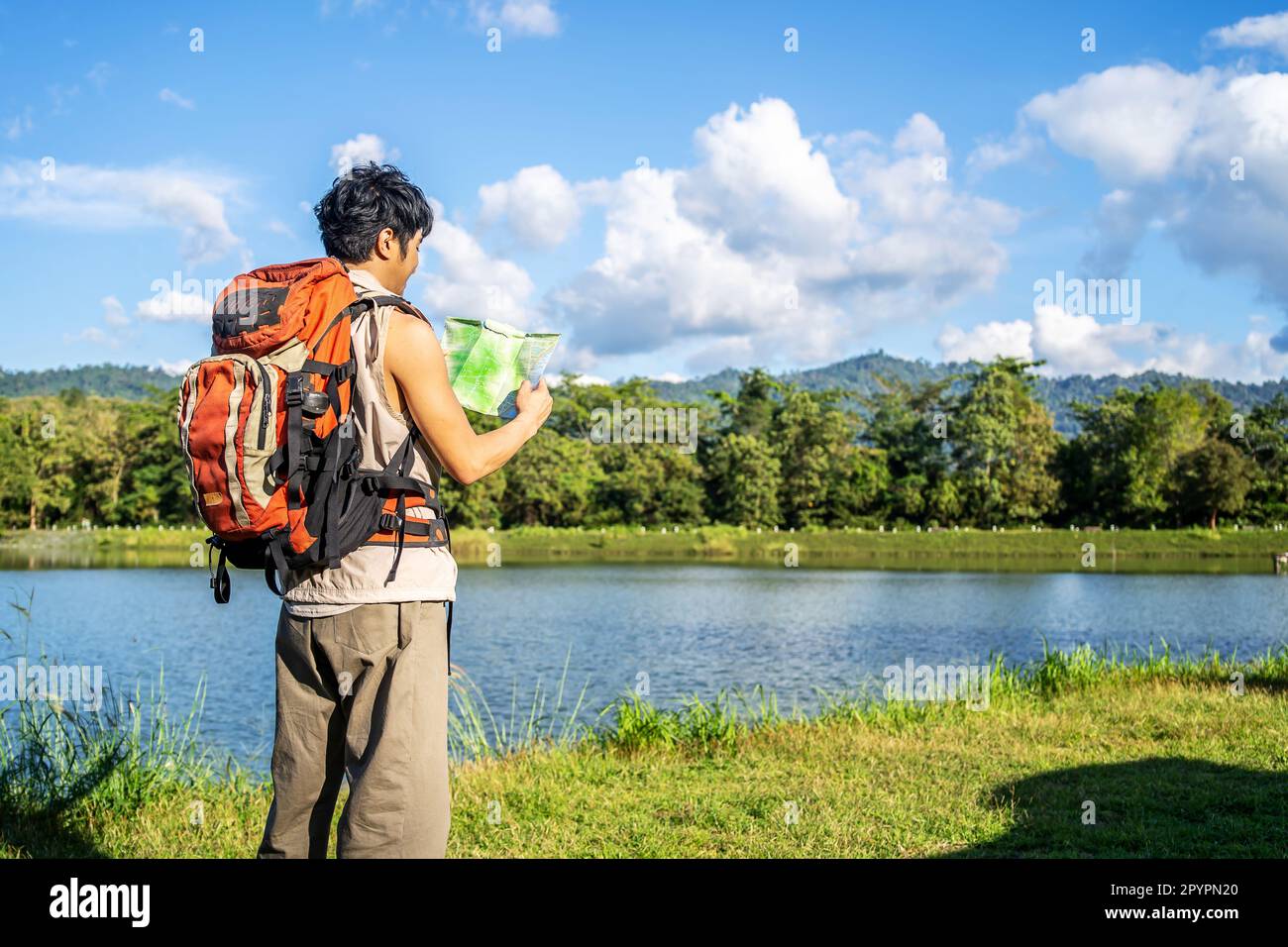 Young attractive male tourists looking for map in forest, Lost hiker ...