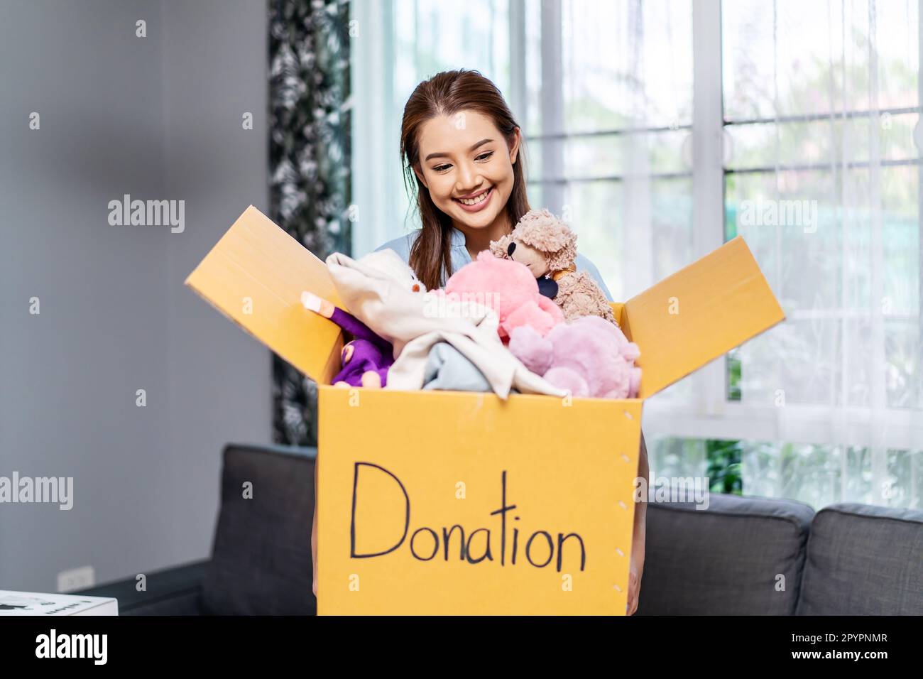 Donation Concept. Happy volunteer asian woman holding a Donate Box with ...