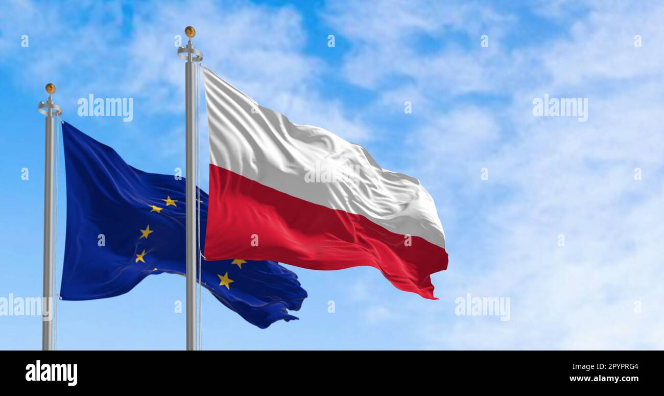 The flags of the Poland and the European Union waving in the wind on a ...