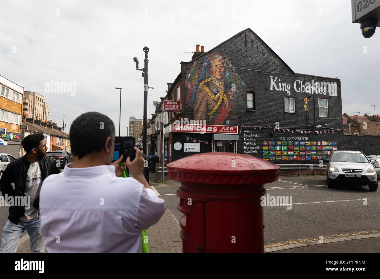 A man takes a pictures of a King Charles III mural by artists Jignesh ...