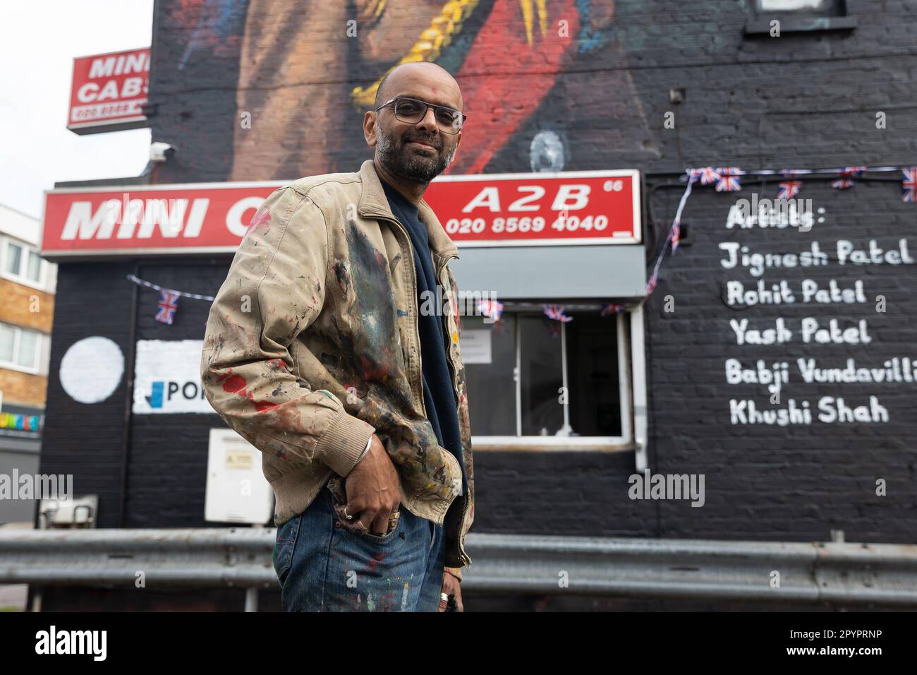 Artist Jignesh Patel, poses in front of his mural of King Charles III ...