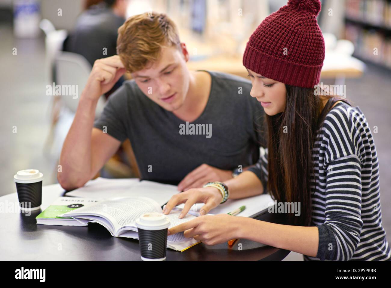 A-students teaming up. two college students studying together at the ...