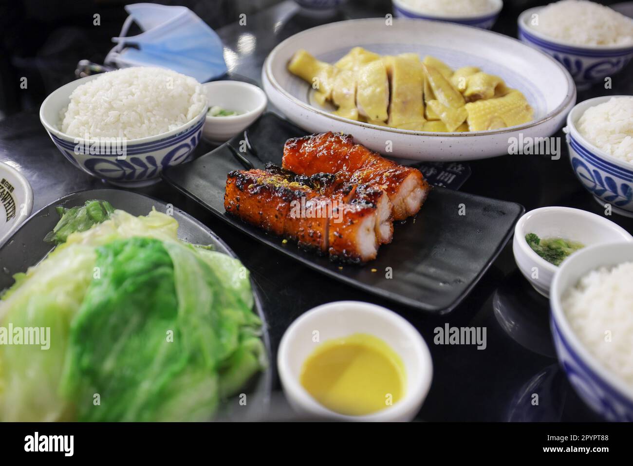 A variety of Asian food and white rice served on a table in a buffet ...