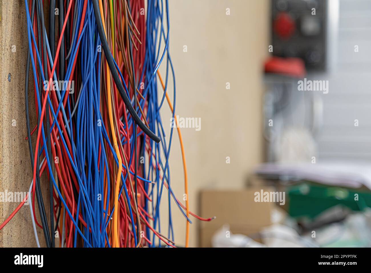 a multicolored electric wires hanging on a wall Stock Photo - Alamy