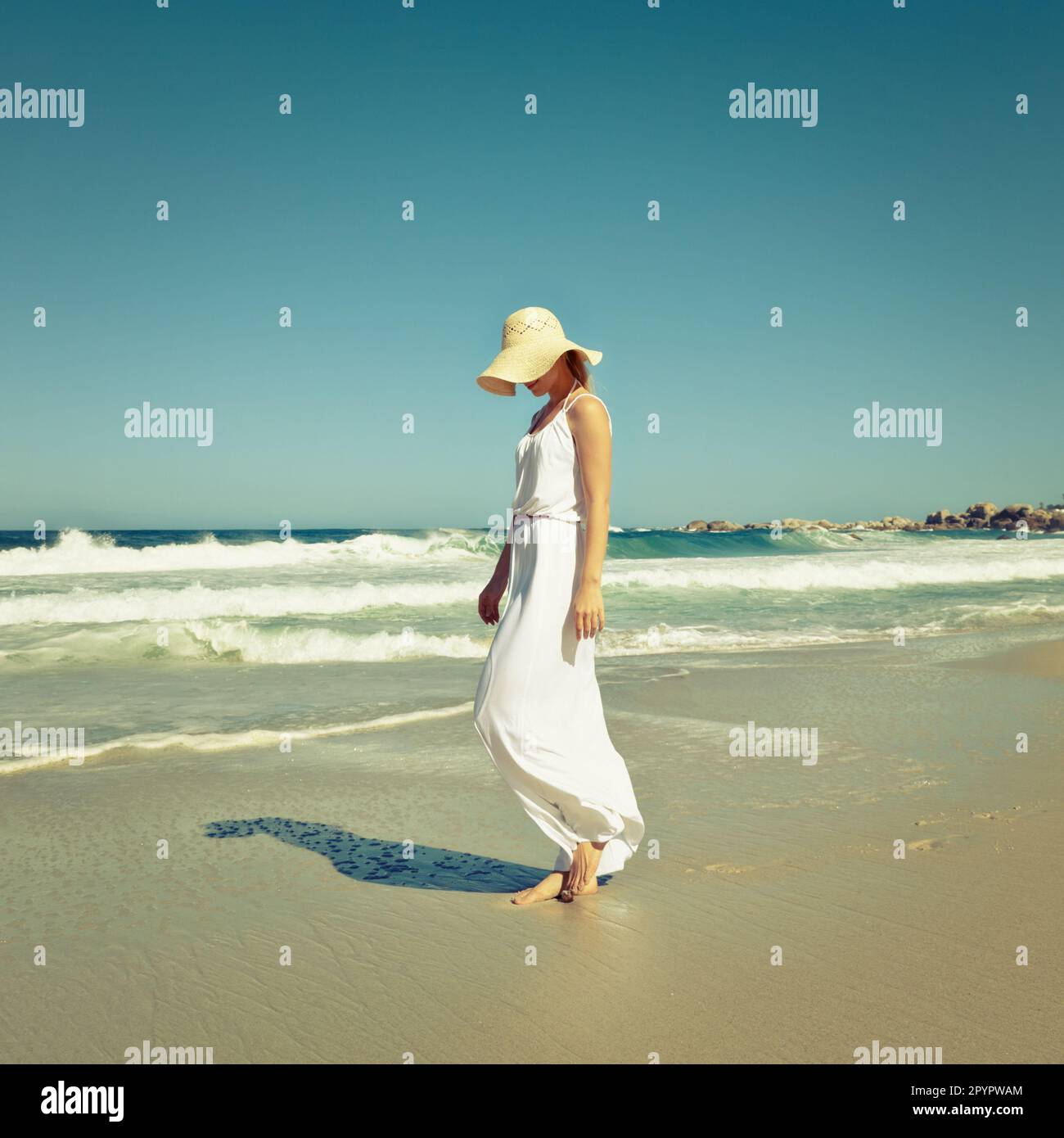 Seaside strolling. a beautiful young woman going for a walk on the ...