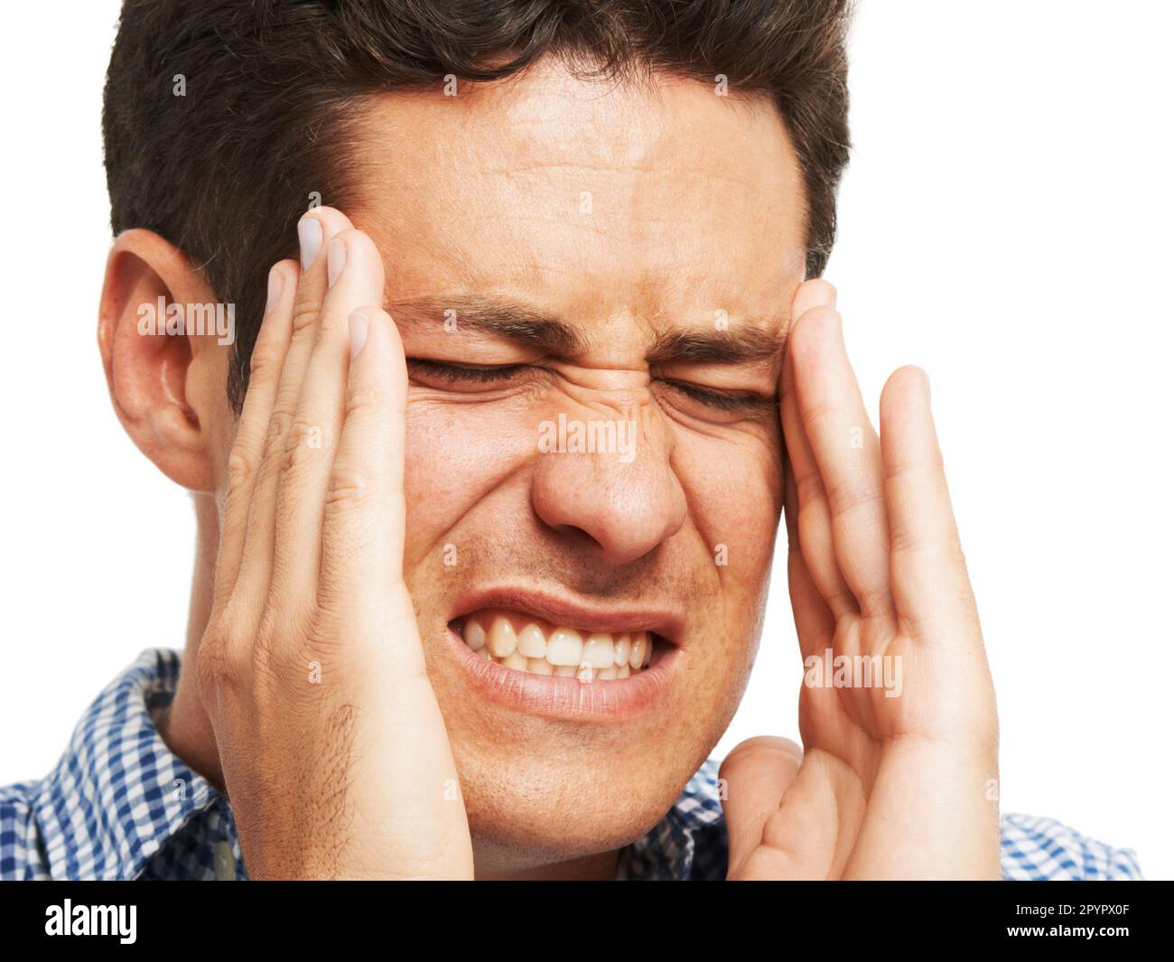 This migraine is unbearable. A young man holding his head as a result of a splitting headache ...