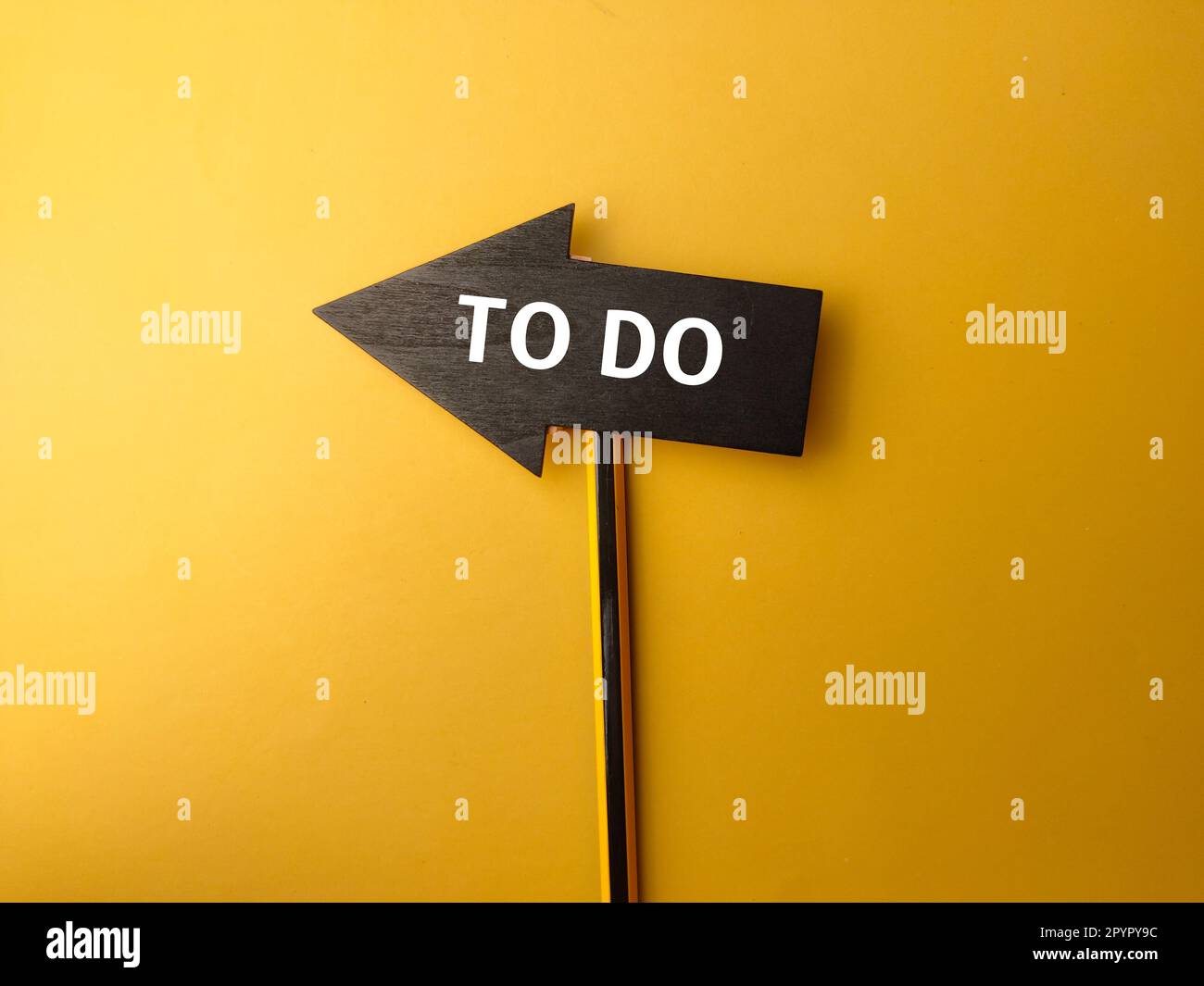 Wooden black arrow with the word TO DO on a yellow background Stock ...