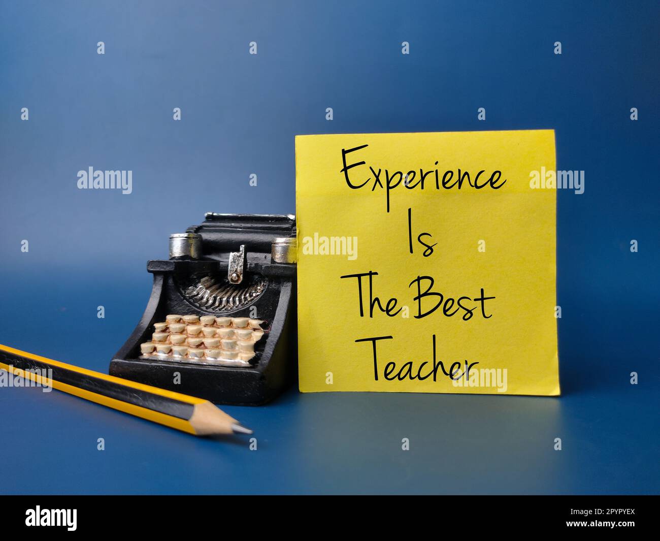 Black vintage typewritter and pencil with the word EXPERIENCE IS THE ...