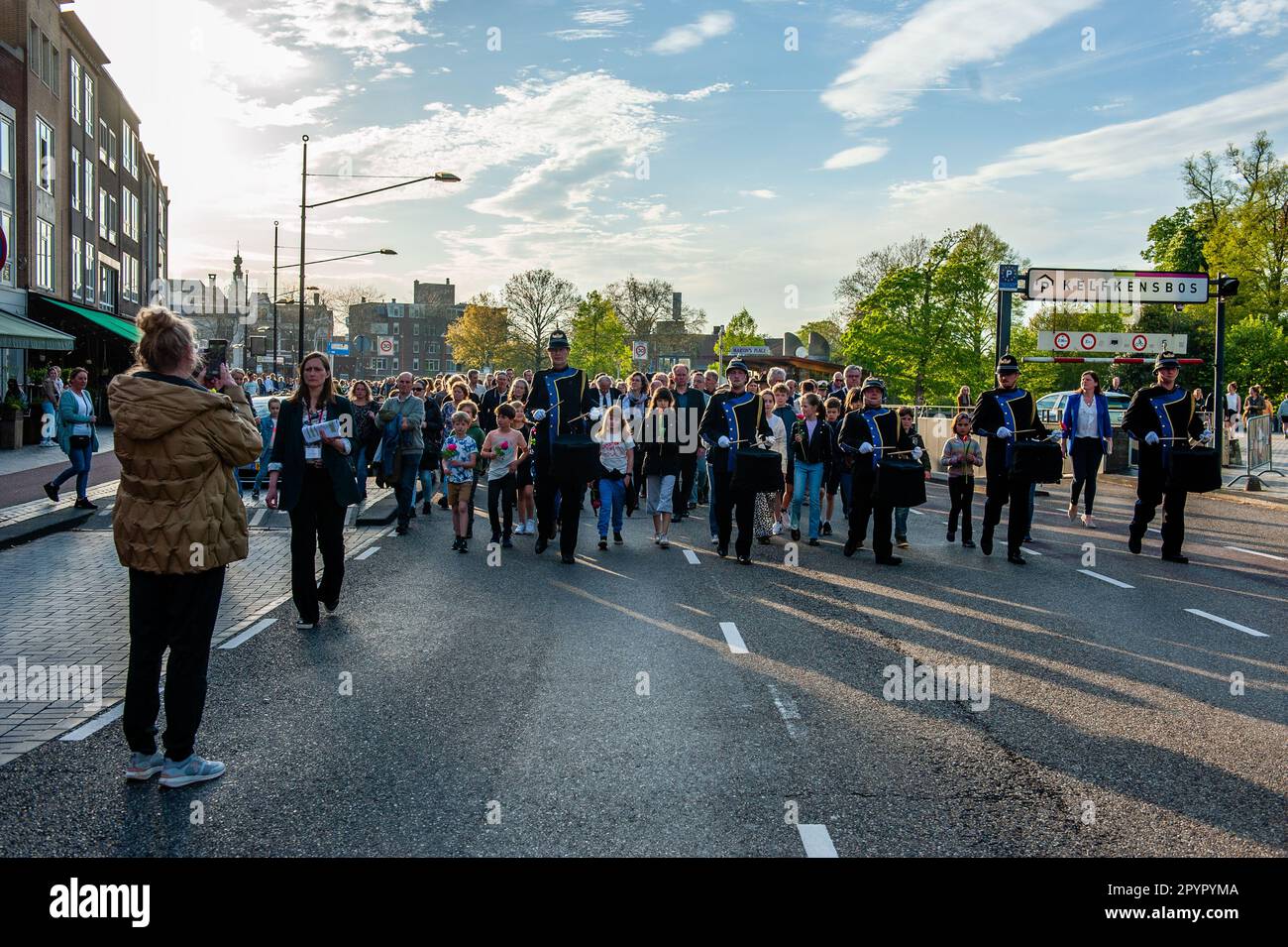A woman is seen taking a photo of the procession passing by. On this ...