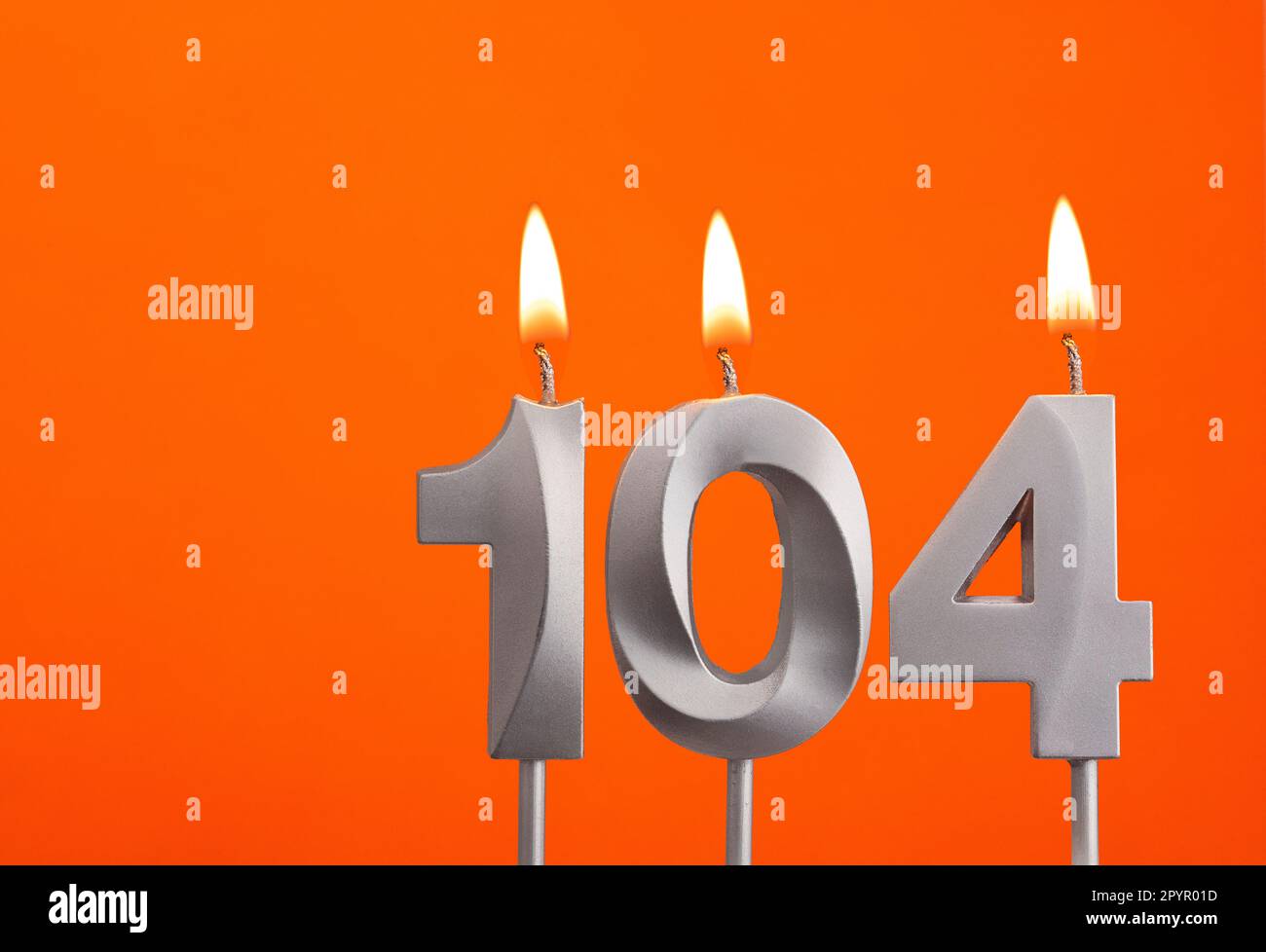 Candle number 104 - Birthday in orange background Stock Photo - Alamy